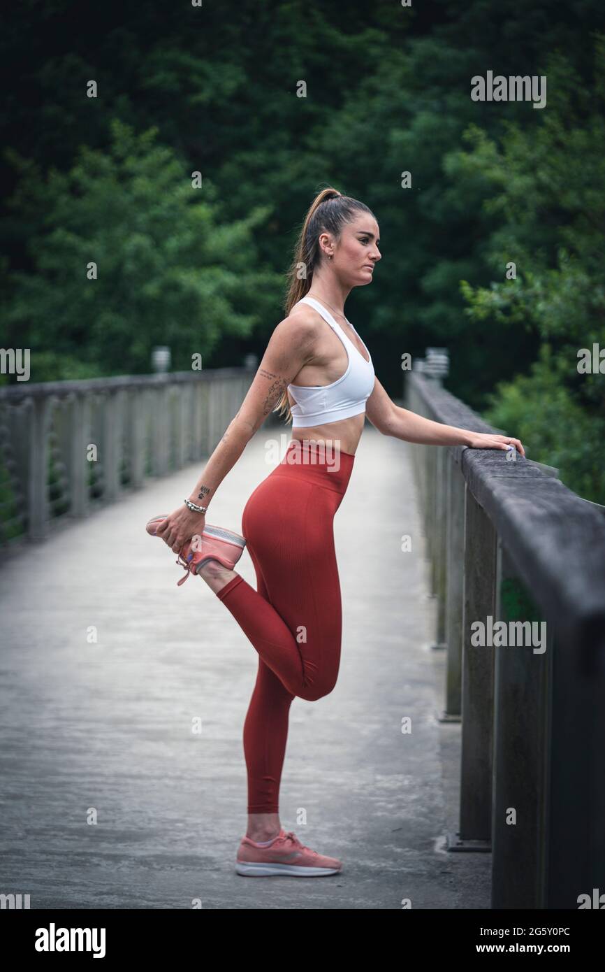 Athlete and runner girl stretching her legs Stock Photo - Alamy