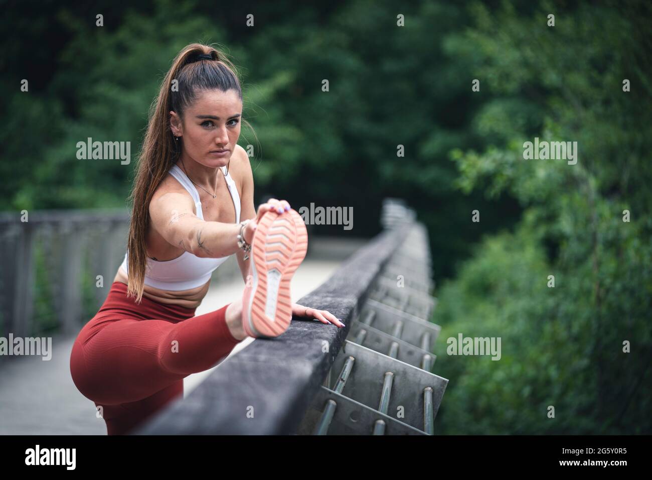 Athlete and runner girl stretching her legs Stock Photo - Alamy