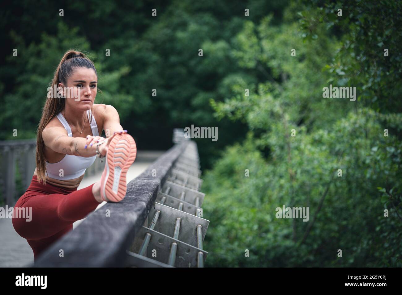Athlete and runner girl stretching her legs Stock Photo - Alamy