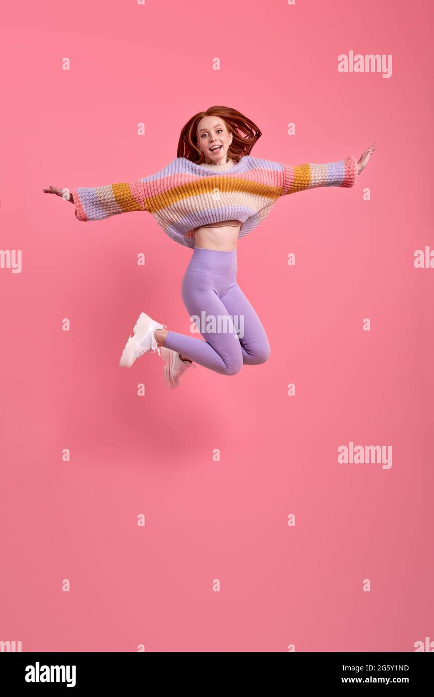 Excited charming young lady dressed in casual outfit jumping running ...