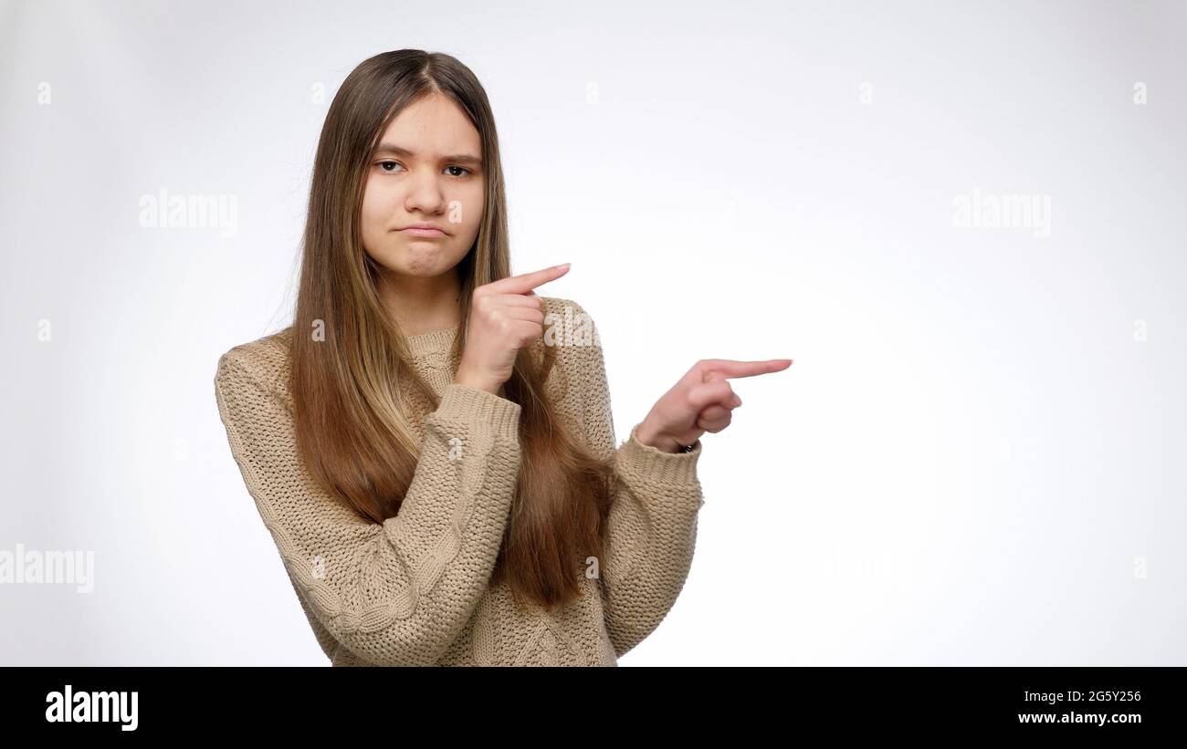Portrait of confident grl pointing on the invisible product on her side ...