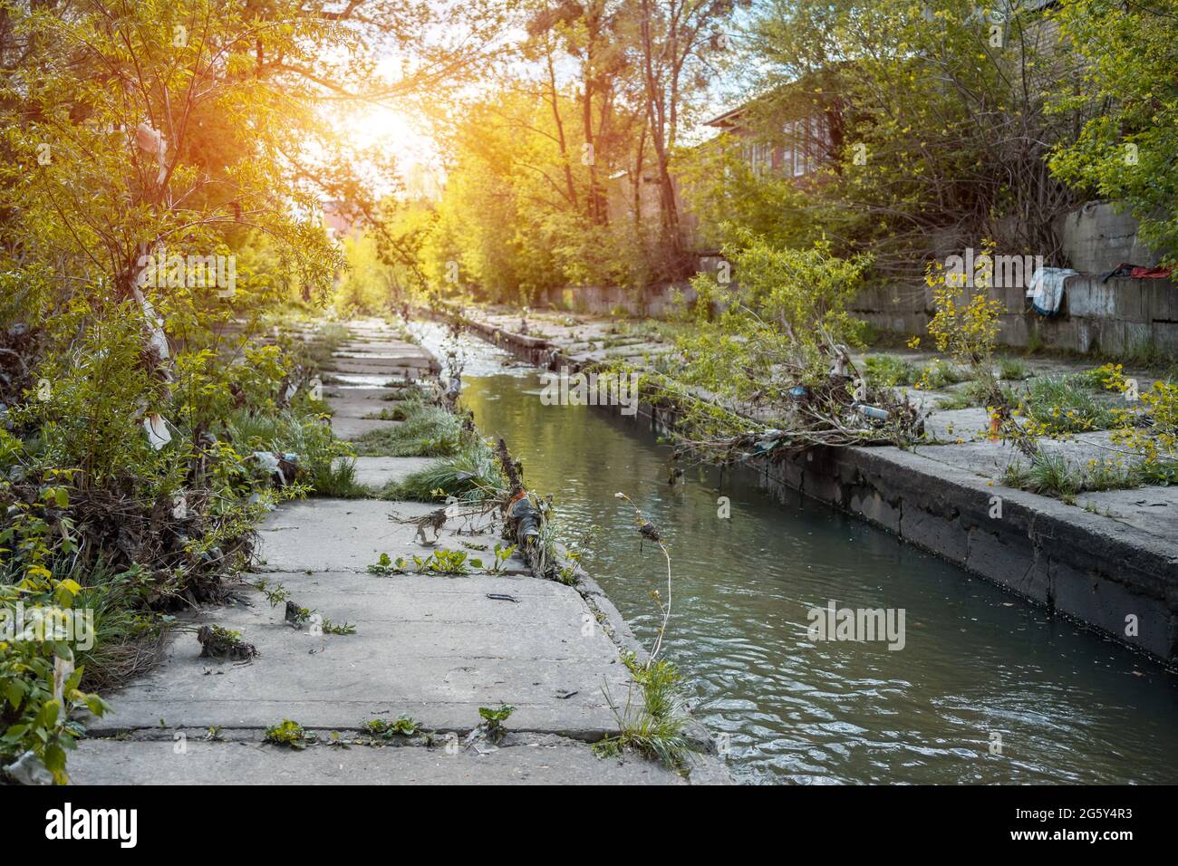 garbage, plastic bags and waste on industrial city river after spring ...