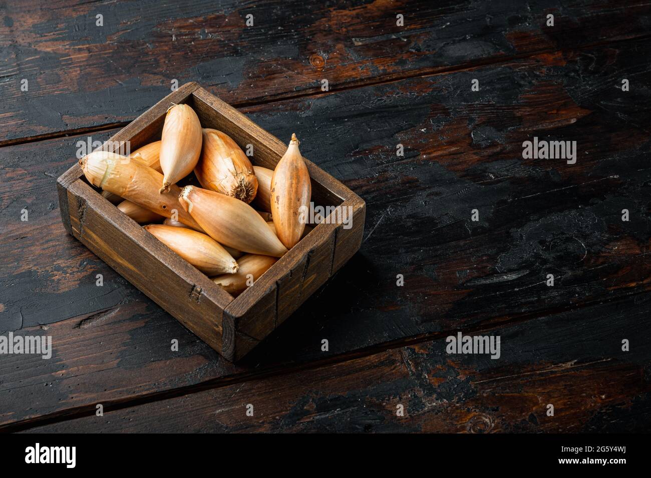 Raw whole baby shallot onion, on old wooden table with space for text ...