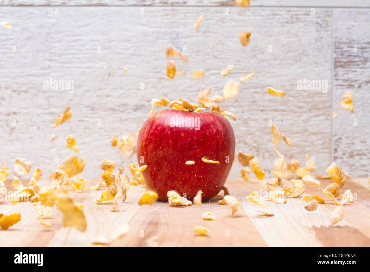 Cereal flakes falling on a red apple Stock Photo - Alamy