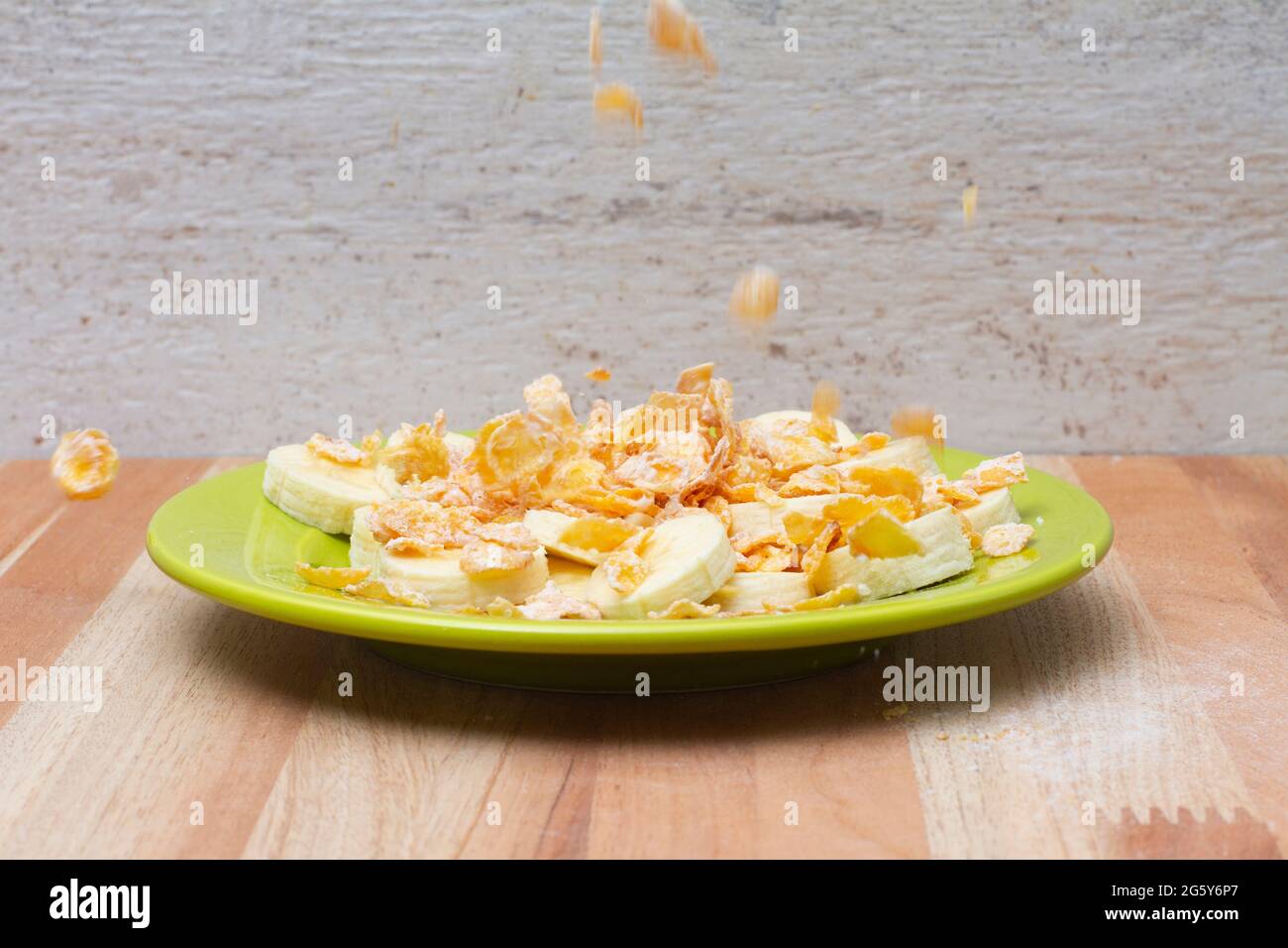 Cereal flakes falling on banana slices Stock Photo - Alamy