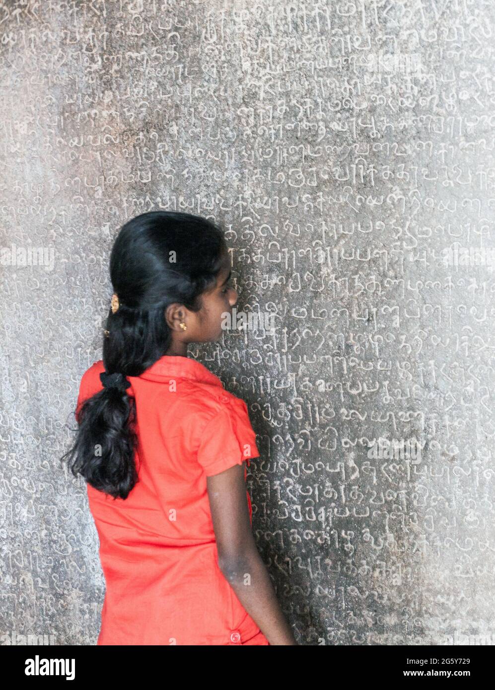 Young Indian female viewing the pallava grantha script engravings at ...