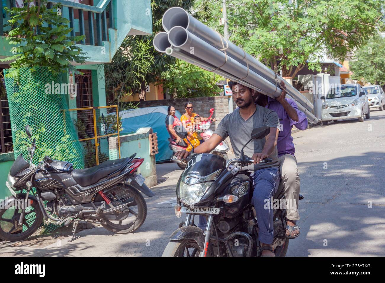 Two Indian males on motorbike driving dangerously carrying long plastic ...