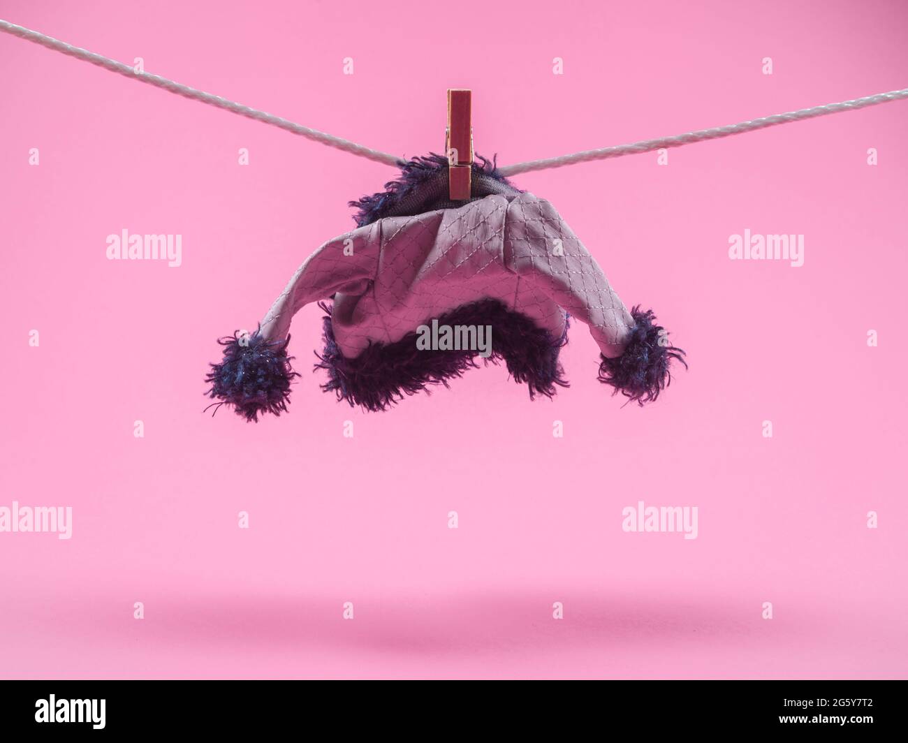 Fashion designer jacket hanging on a rope clipped with pegs. On trendy ...