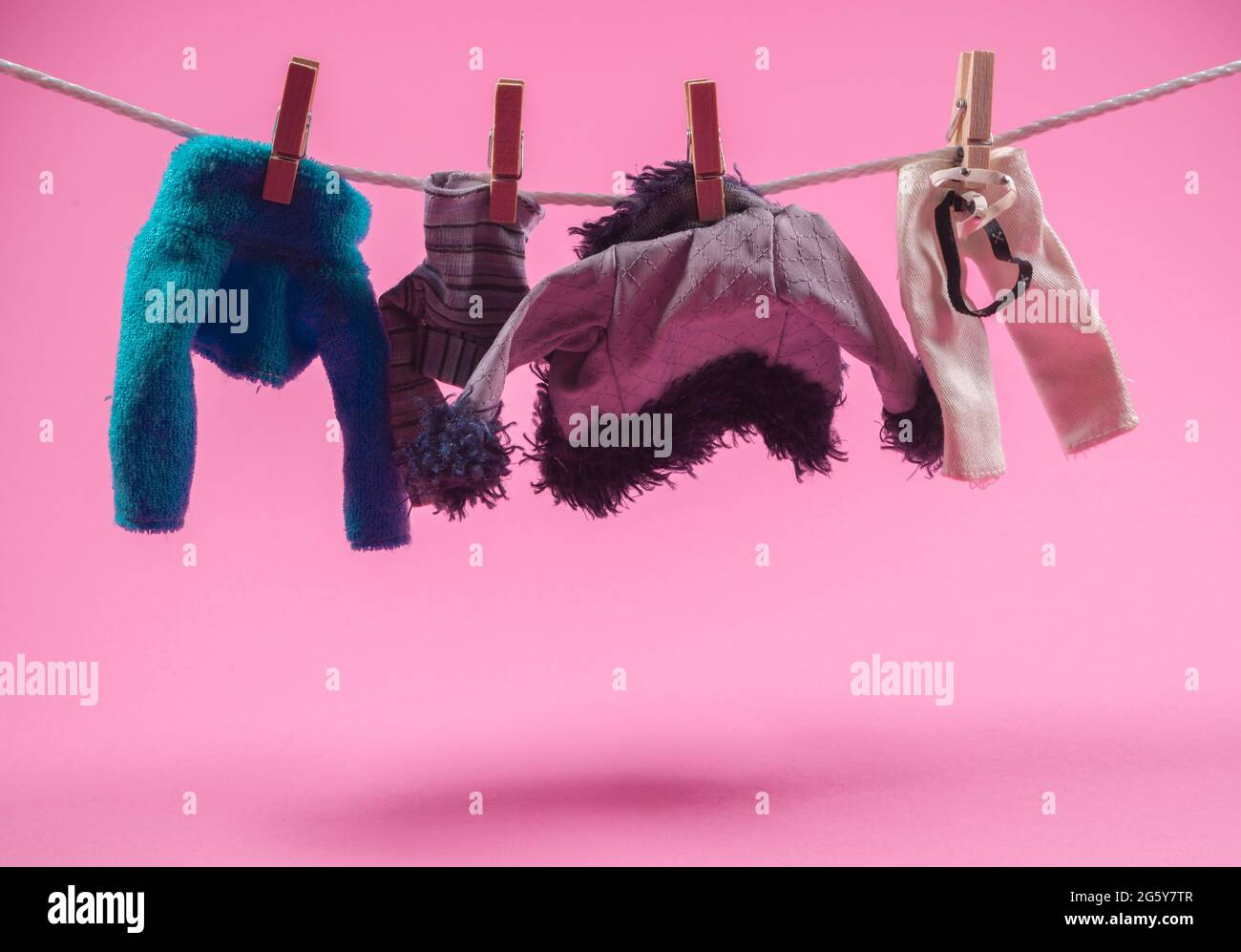 Fashion designer clothes hanging on a rope clipped with pegs. On trendy ...