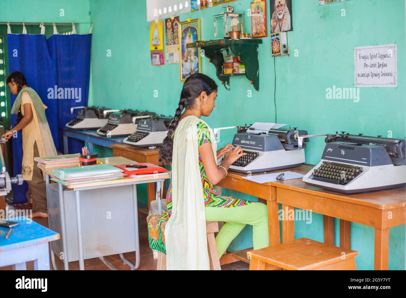 Young Indian female with hair plaited wearing salwar kameez seated at ...