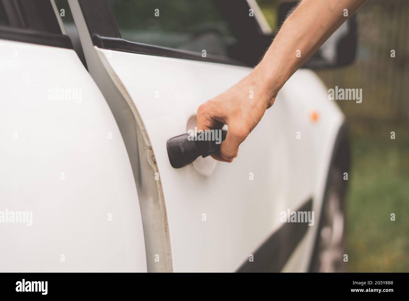 casual person opens the white car door on the parking, car rental ...