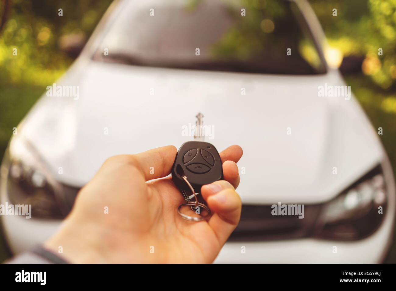 driver hand holding a wireless remote control keys to open the car ...
