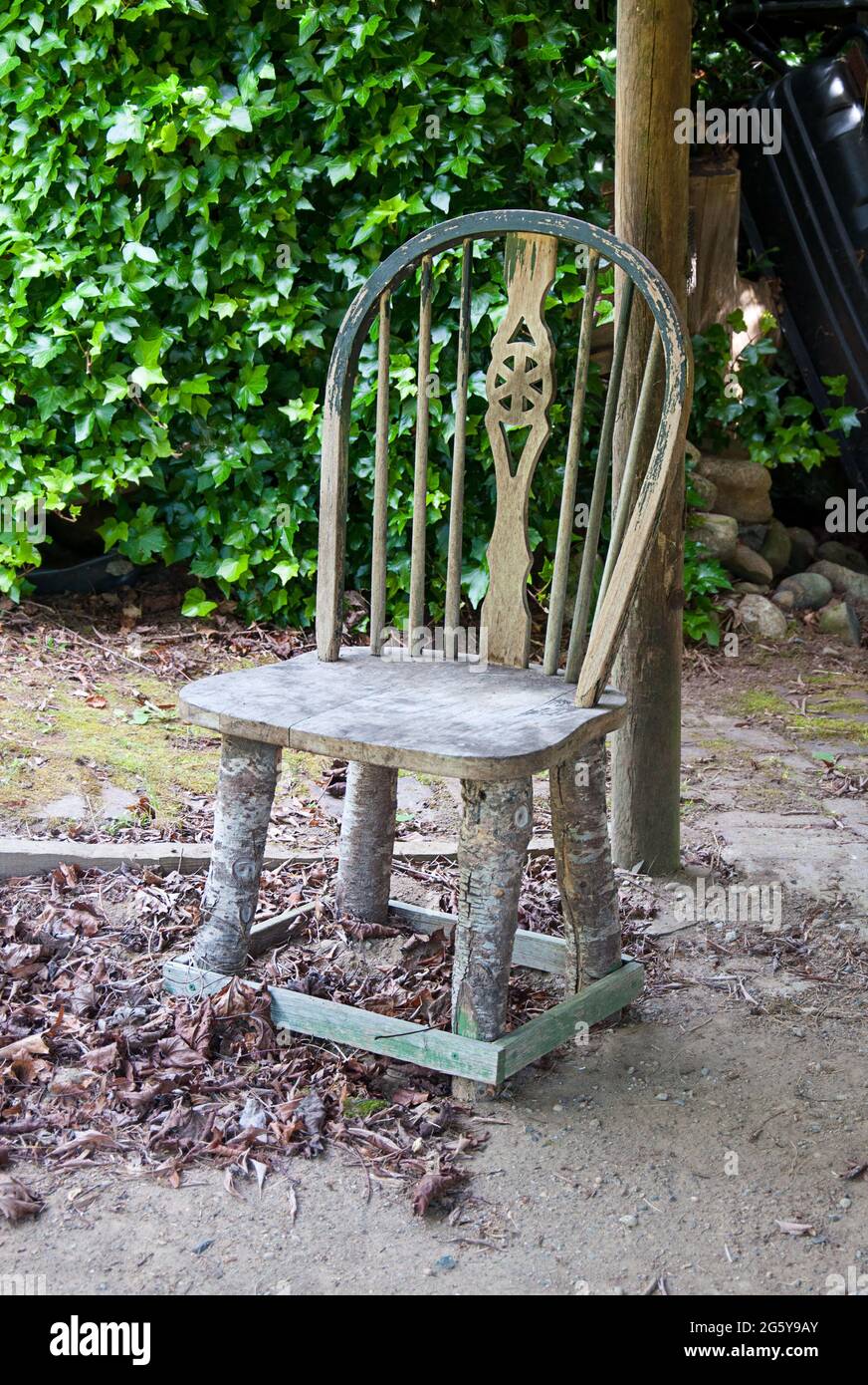 Rustic wood chair outdoors which legs have been made by tree branches ...