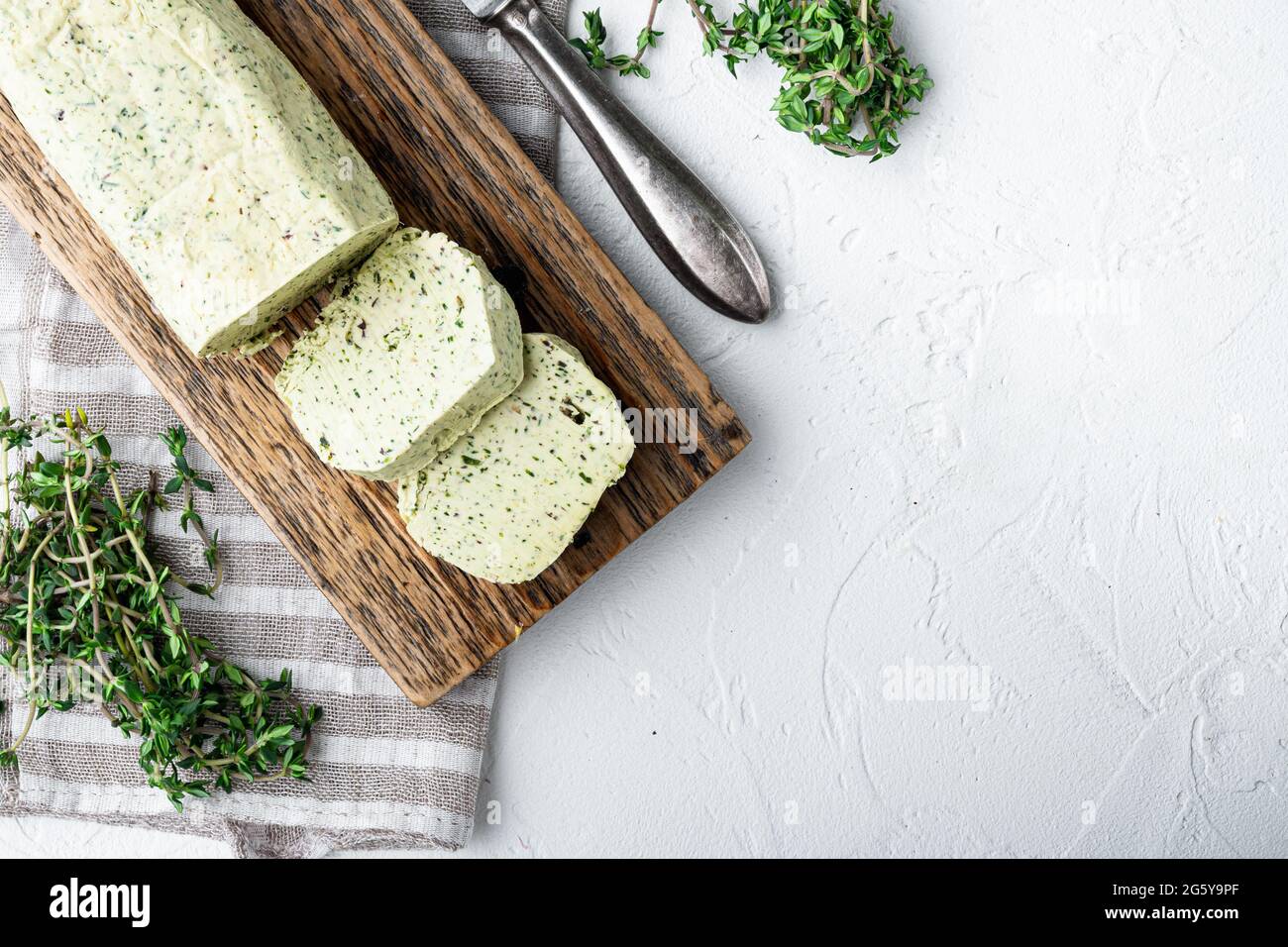 Fresh green herb butter set, on white stone background, with copy space ...