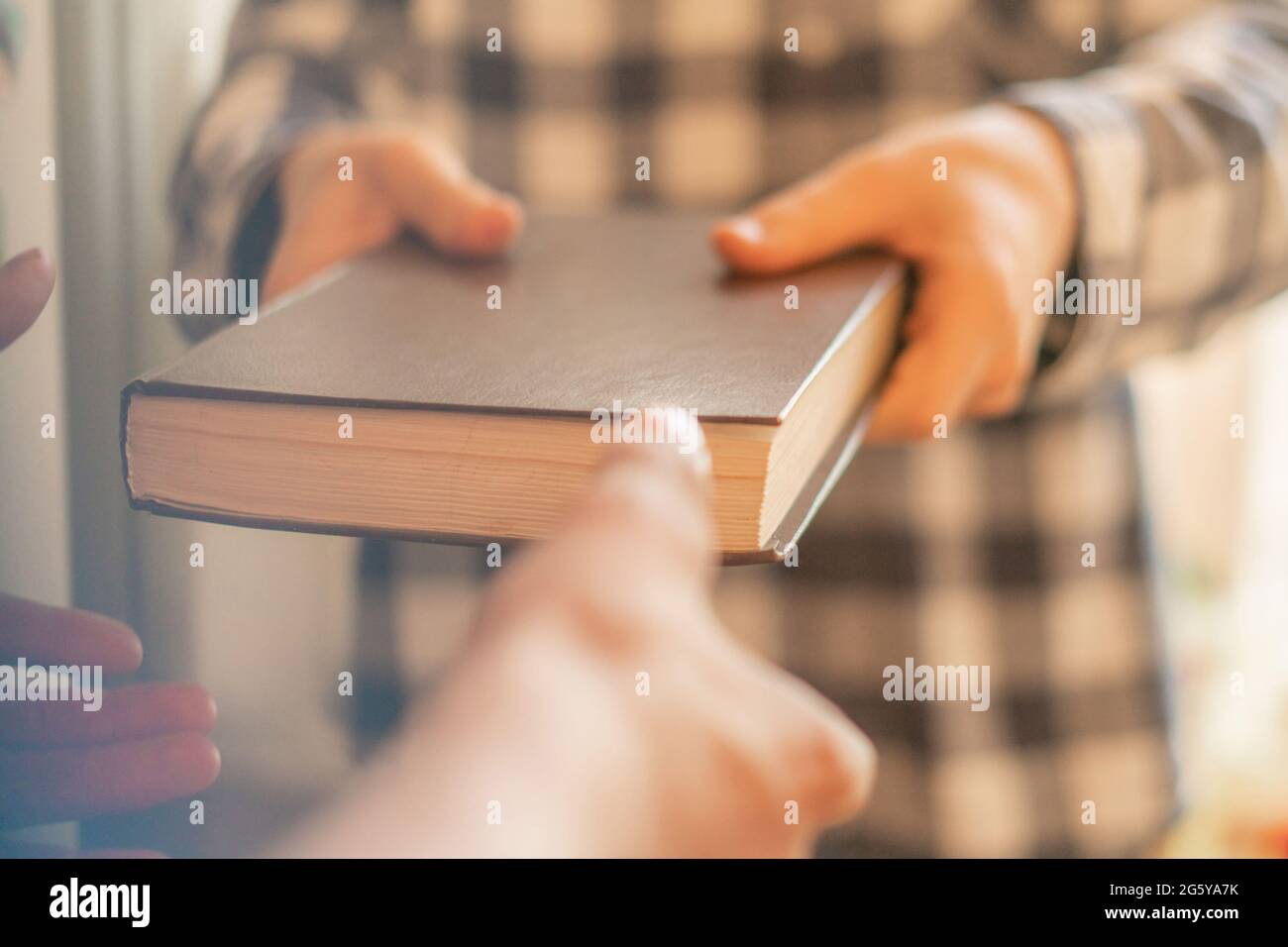 two people exchange the book, giving the knowledge to younger ...