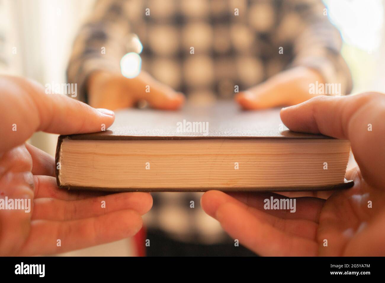 two people exchange the book, giving the knowledge to younger ...
