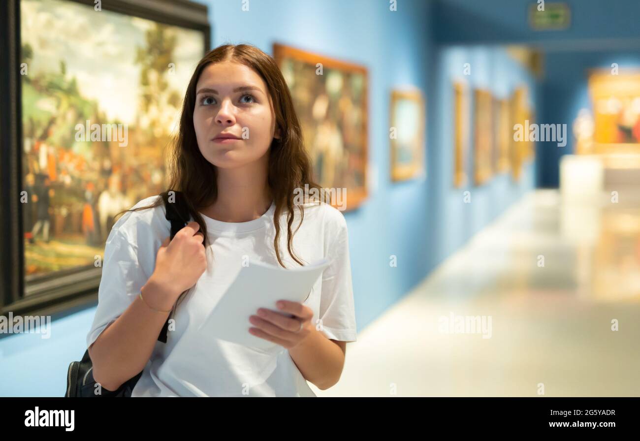 Portrait of a young girl visitor on at the exhibition of paintings in ...
