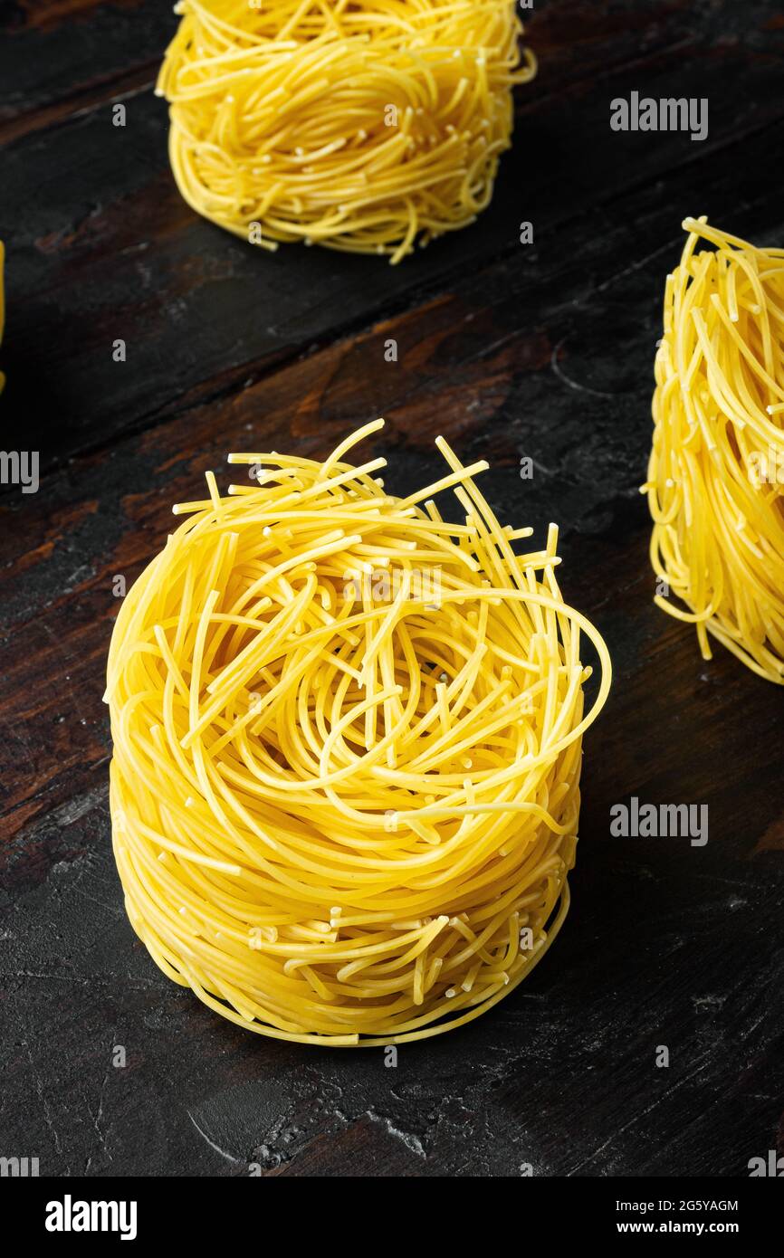 Durum wheat semolina homemade egg pasta tagliarini set, on old dark ...