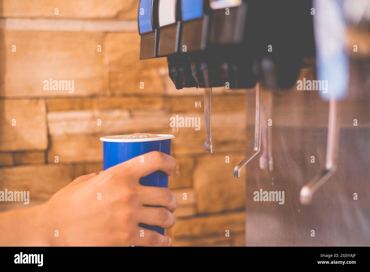 hand holding a paper glass to pour the lemonade soda soft drink machine ...