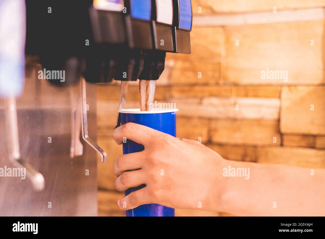 hand holding a paper glass to pour the lemonade soda soft drink machine ...