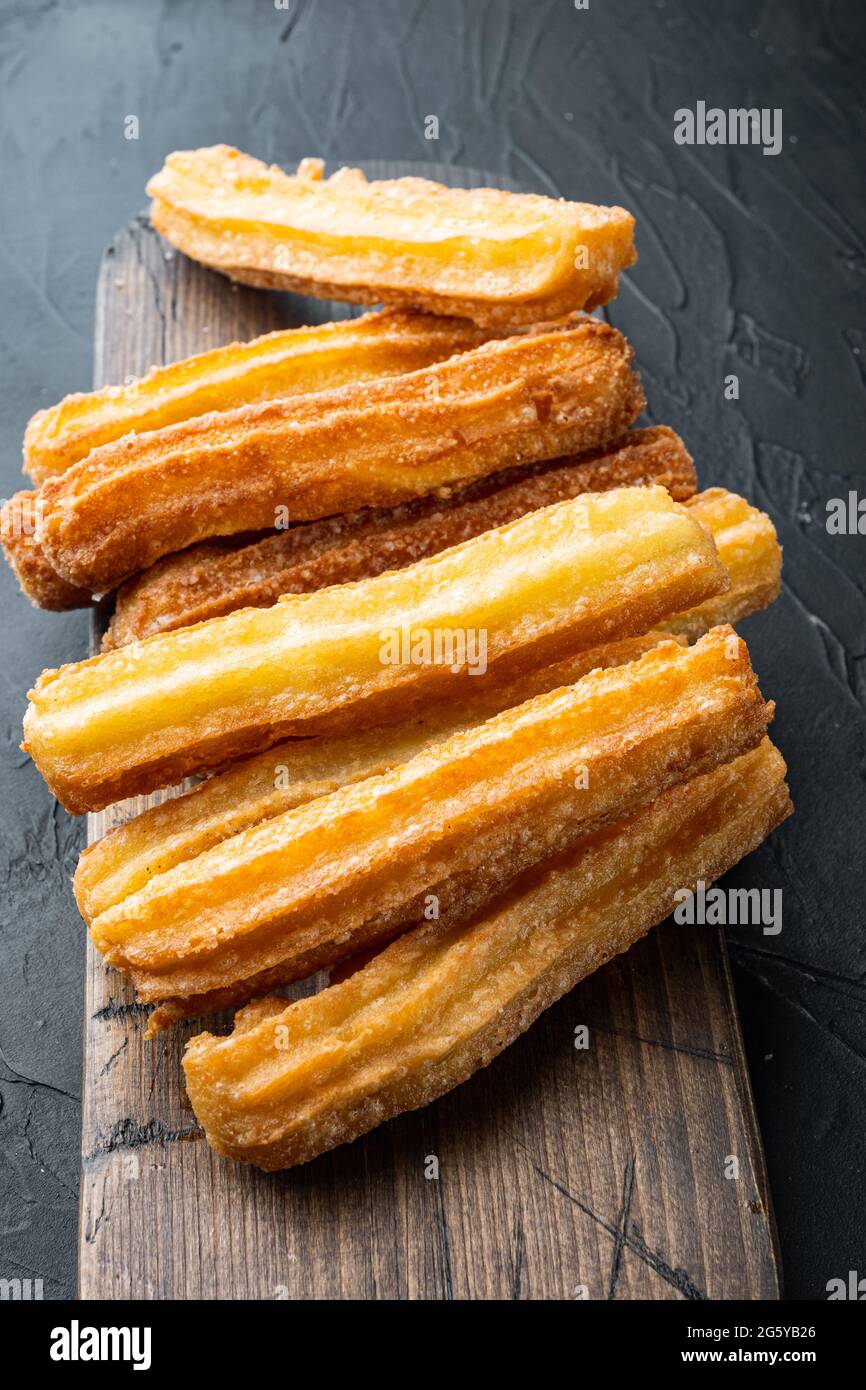 Traditional churros sticks with cinnamon and sugar powder set, on black ...