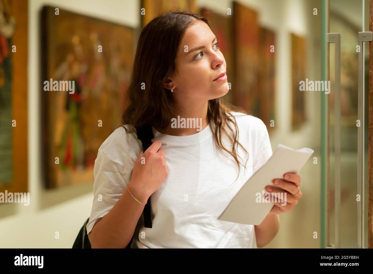 Girl visitor looks at the exhibit in the museum, located behind the ...