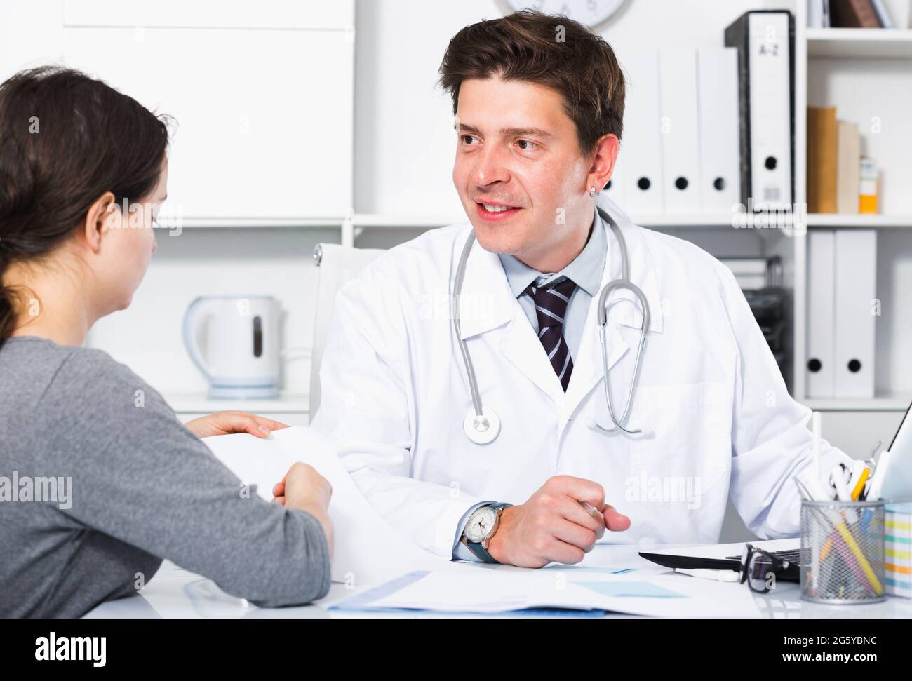 Doctor speaking with client in the medical center Stock Photo - Alamy