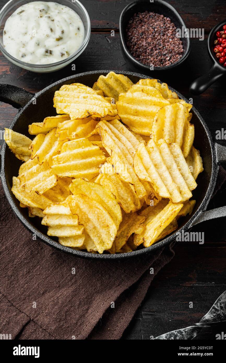 Delicious crispy potato chips, with sour cream, on old dark wooden ...