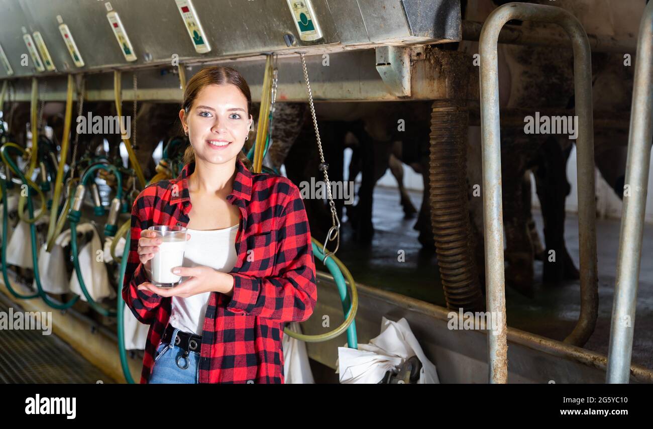 Female milker posing with glass of milk on dairy farm Stock Photo - Alamy