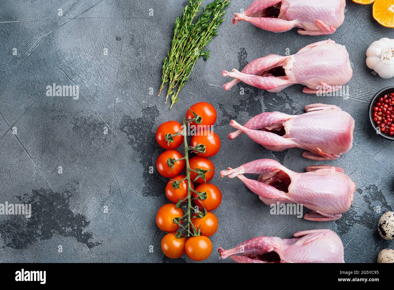 Fresh raw meat quails with herbs, flat lay, on grey background with ...