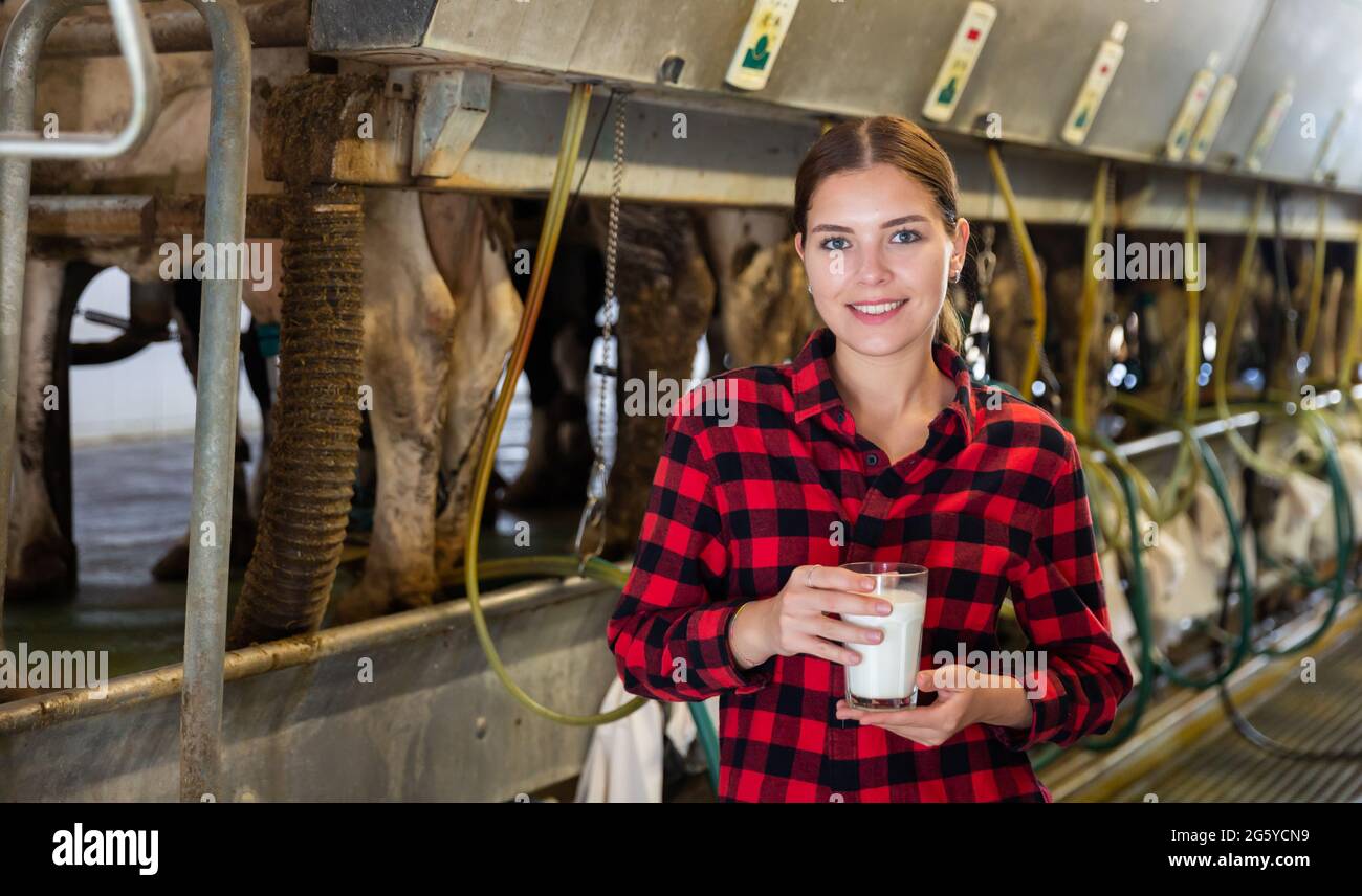 Portrait Of A Positive Young Girl Standing With A Glass Of Milk Near