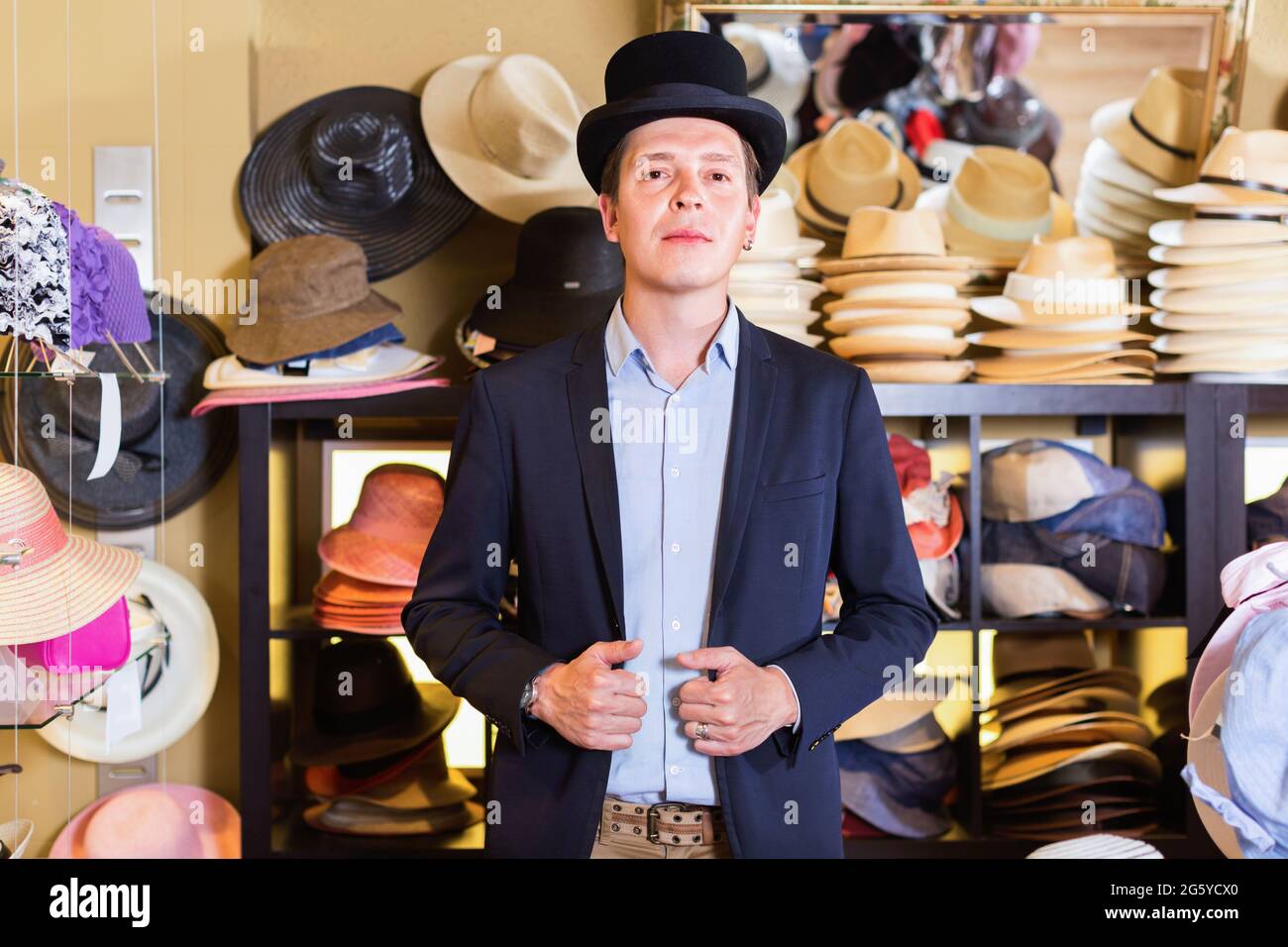 Male shopping in botique and try on top hat Stock Photo - Alamy