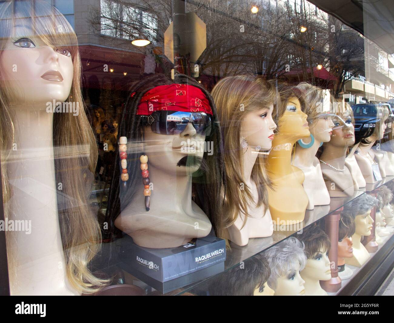 Wigs are displayed in a storefront window Stock Photo - Alamy