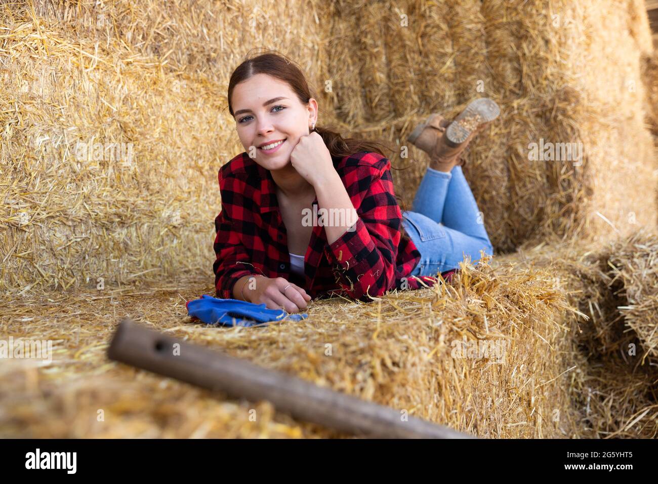 Happy girl resting after hard work in hayloft Stock Photo - Alamy