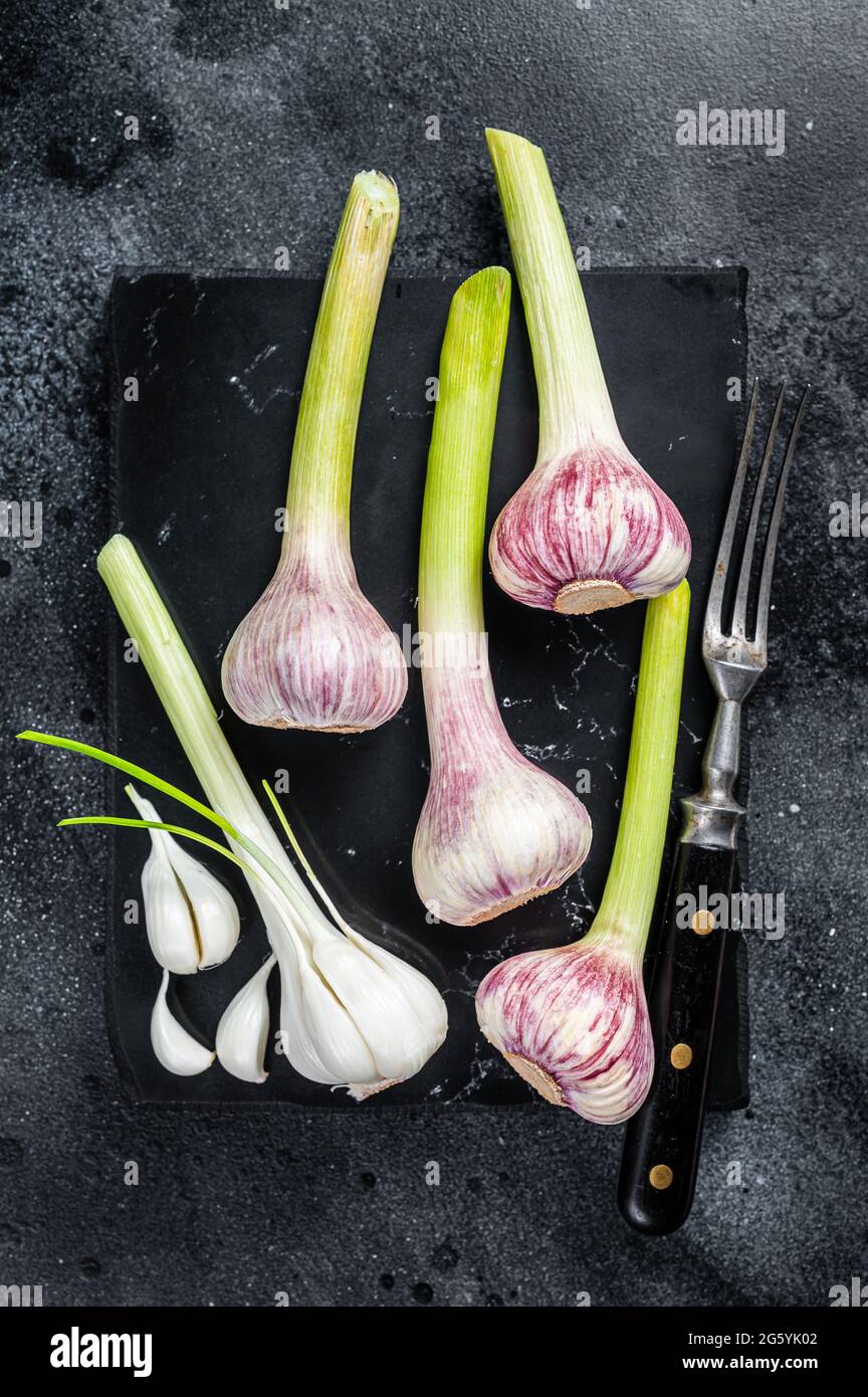 Raw Spring young garlic bulbs and cloves on marble board. Black ...
