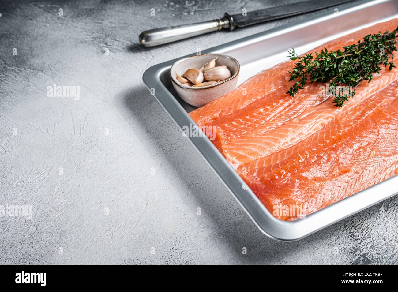 Raw uncooked sea salmon fillet fish in a kitchen tray with herbs. White ...