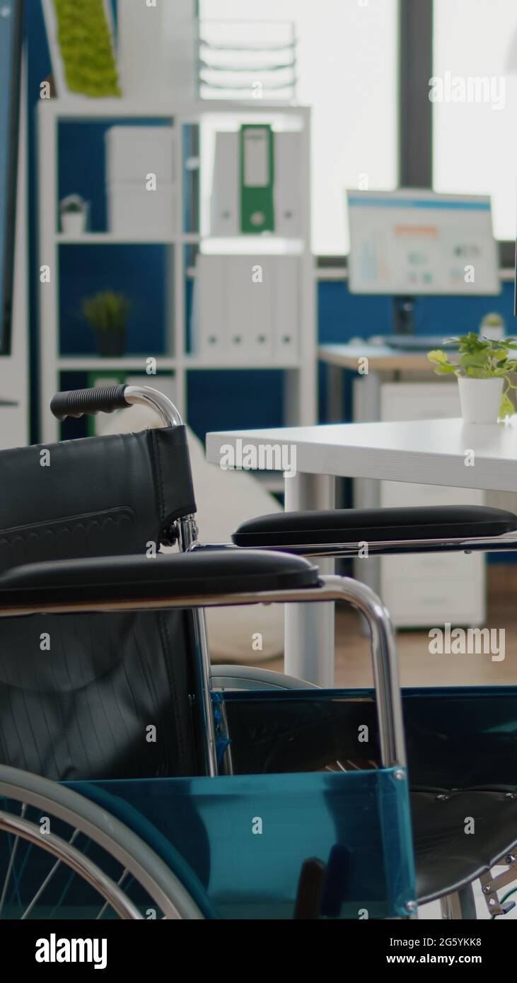 Interior of cozy light company room with wheelchair parked near desk ...