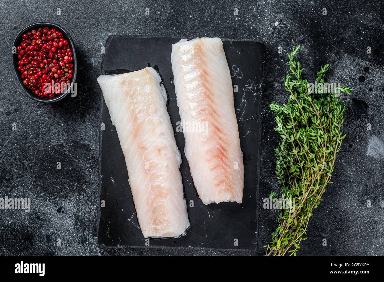 Raw cod loin fillet fish on marble board. Black background. Top view ...