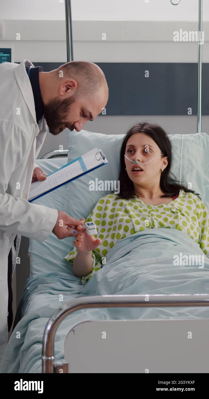 Specialist doctor monitoring sick woman examining pulse oximeter ...