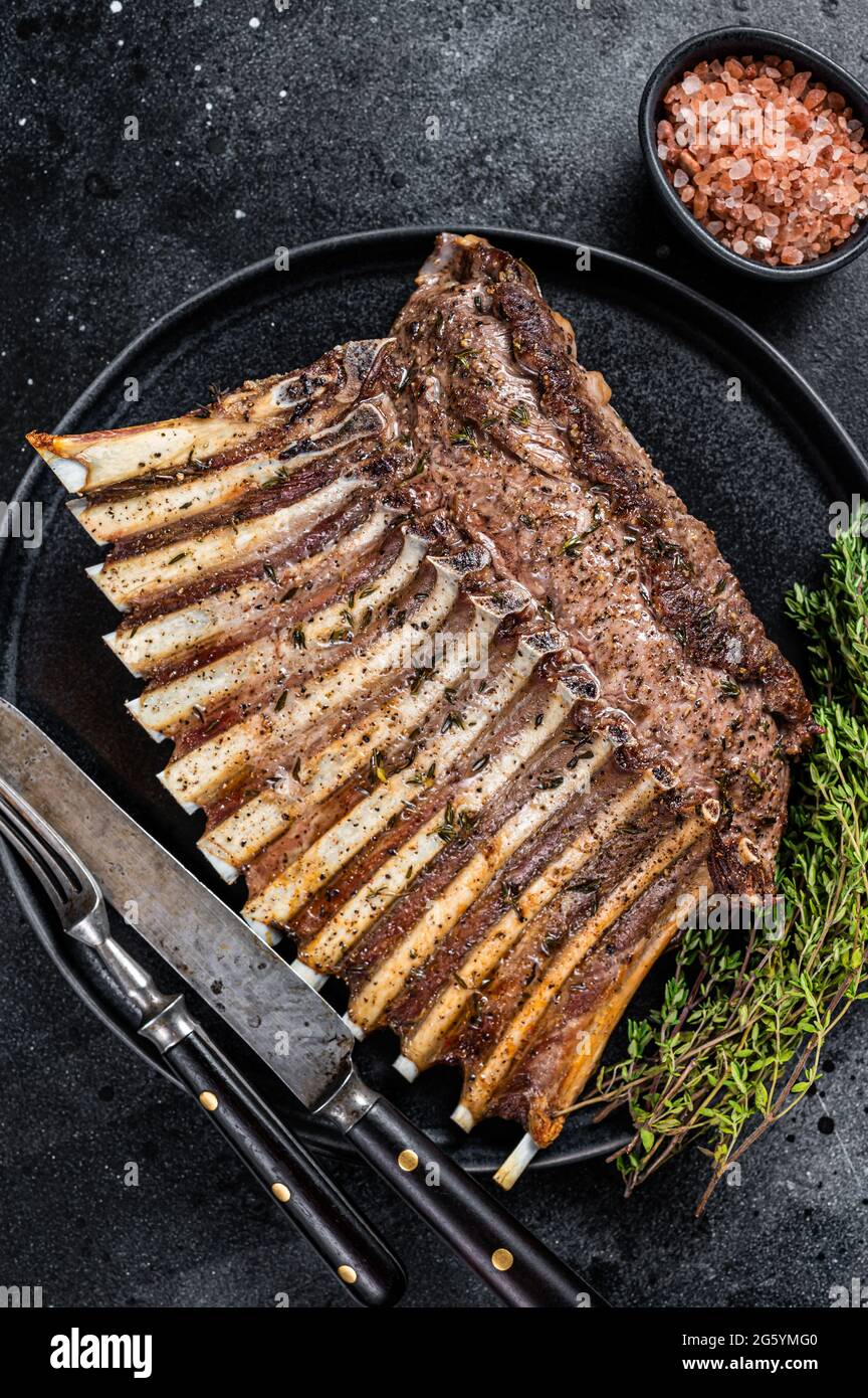 BBQ Grilled rack of Lamb mutton Ribs Chops on plate with thyme. Black ...
