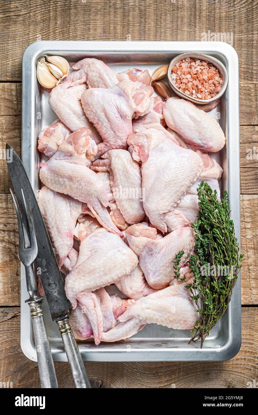 Raw chicken wings Poultry meat ready for cooking with herbs. Wooden ...