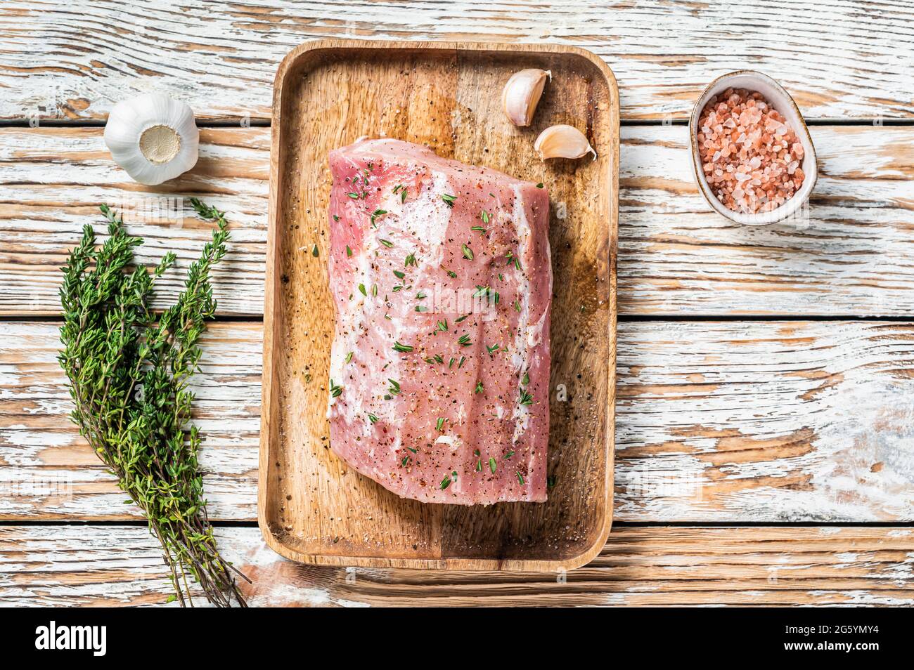 Raw Whole Boneless Pork Loin Meat With Thyme And Salt On Rustic Board
