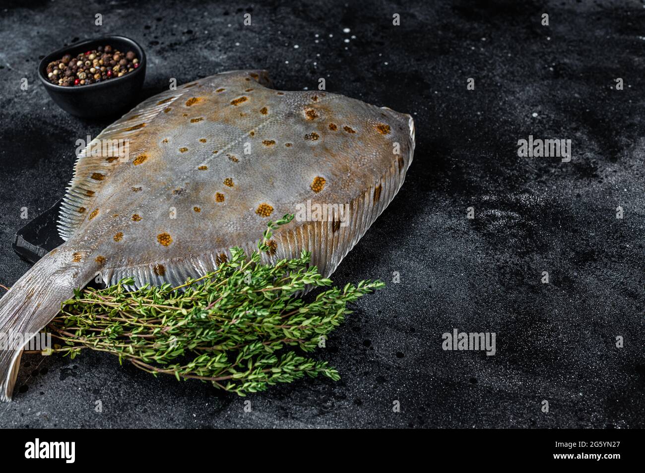 Raw flounder flatfish fish on marble board with thyme. Black background ...