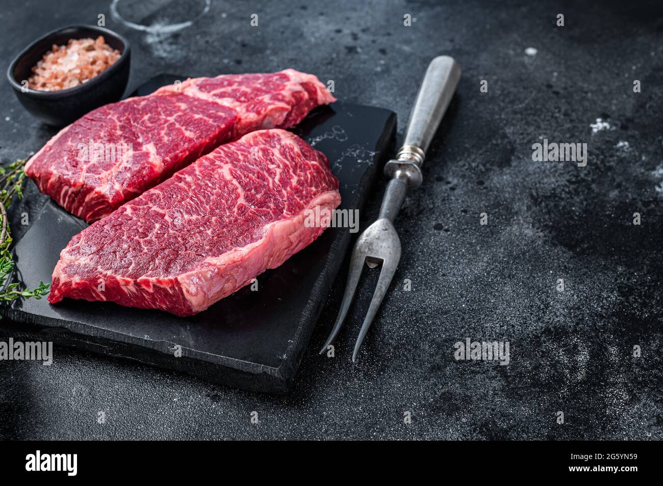 Fresh Raw Denver steak Marble beef meat with herbs. Black background ...