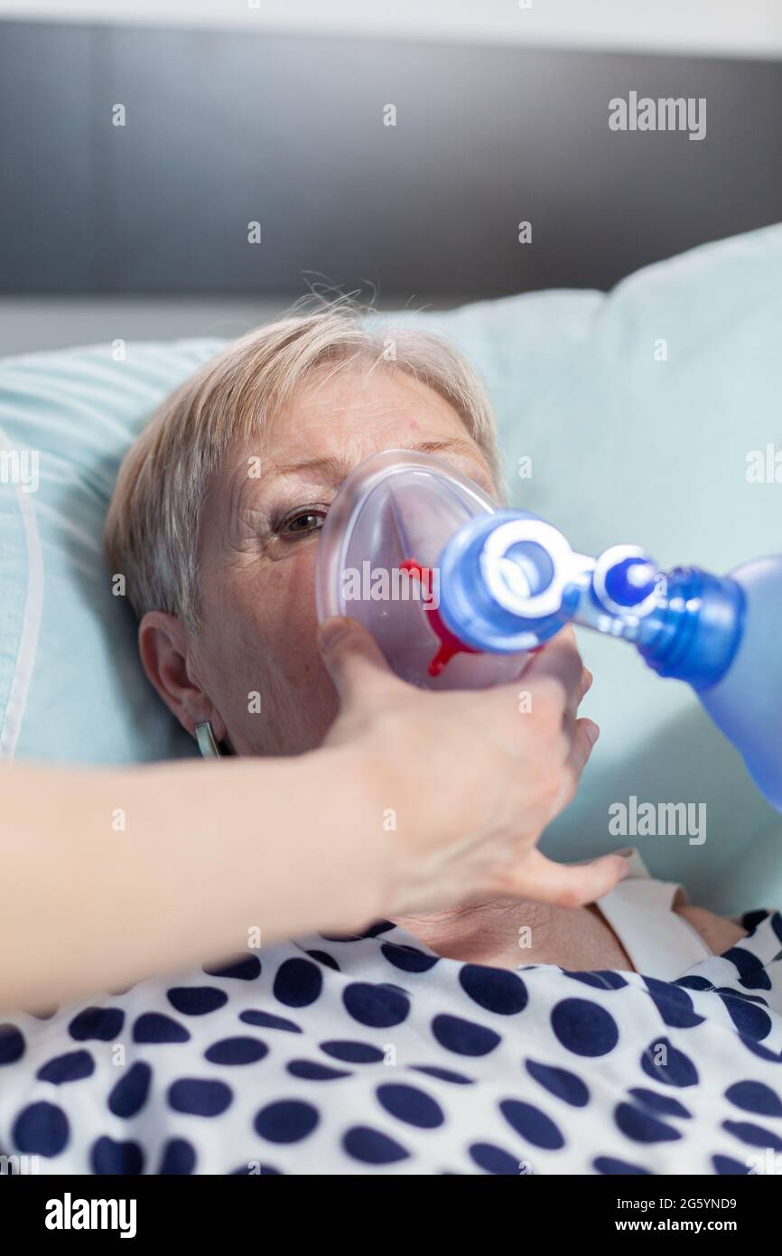 Close up shot of sick senior woman inhale and exhale with help from ...