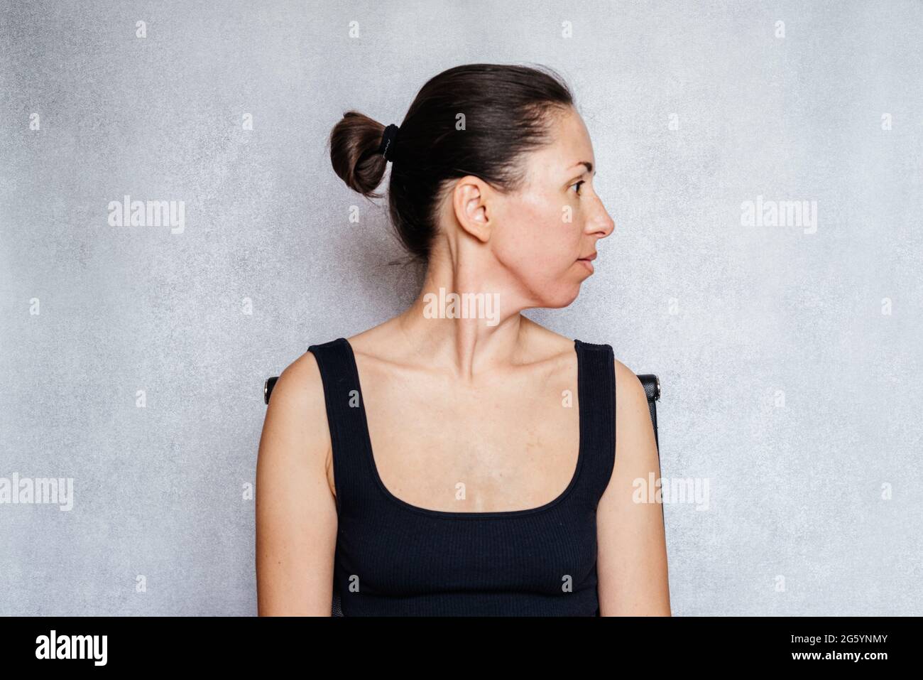 McKenzie method exercise to relieve neck pain, a woman gently rotates ...
