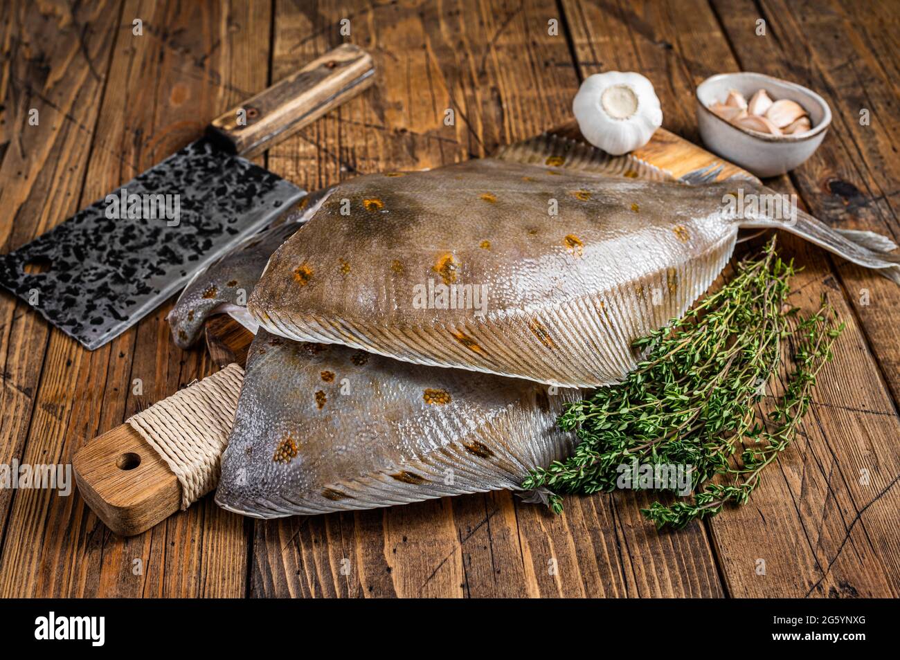 Raw flounder flatfish on butcher board with cleaver. wooden background ...
