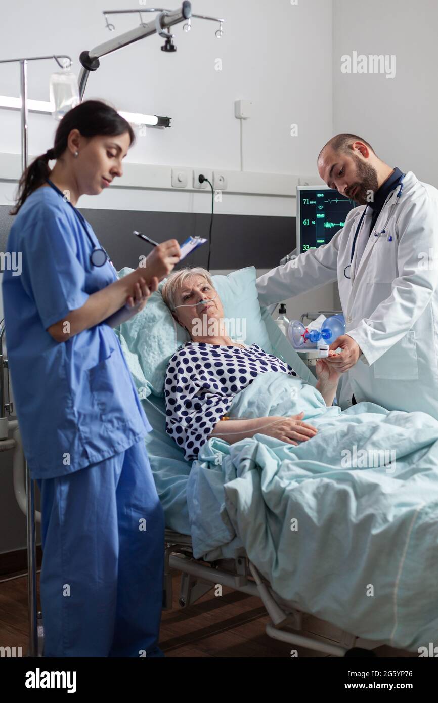 Doctor checking senior patient in hospital intensive care, checking ...