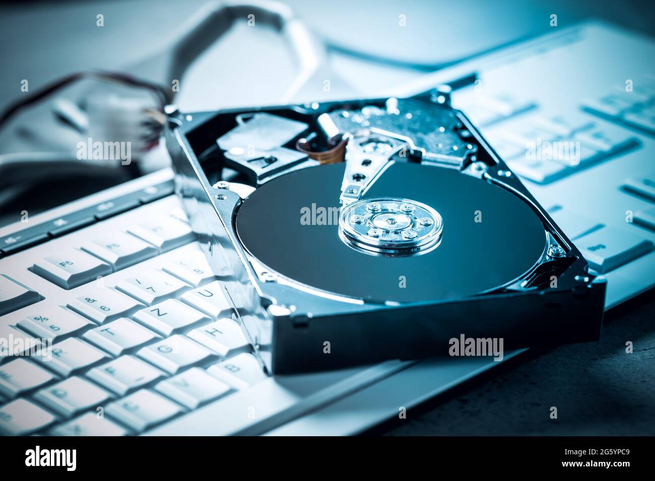 Hard drive on keyboard in blue tone Stock Photo - Alamy
