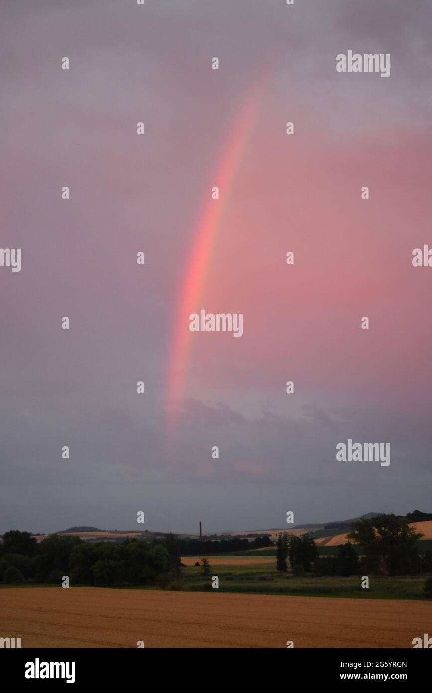 rainbow in red dusk clouds Stock Photo - Alamy